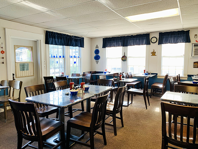 A dining room that says "stay awhile"—simple, clean, and bathed in natural light from windows framed with those quintessential blue valances.