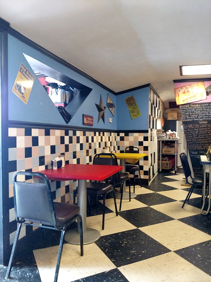 Primary-colored tables pop against the classic diner backdrop—a playful touch that makes every meal feel like a special occasion.