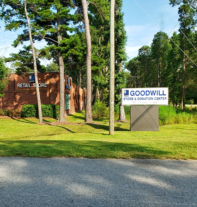 Nestled among tall pines, the Goodwill sign stands as a beacon for bargain hunters and sustainability champions alike.