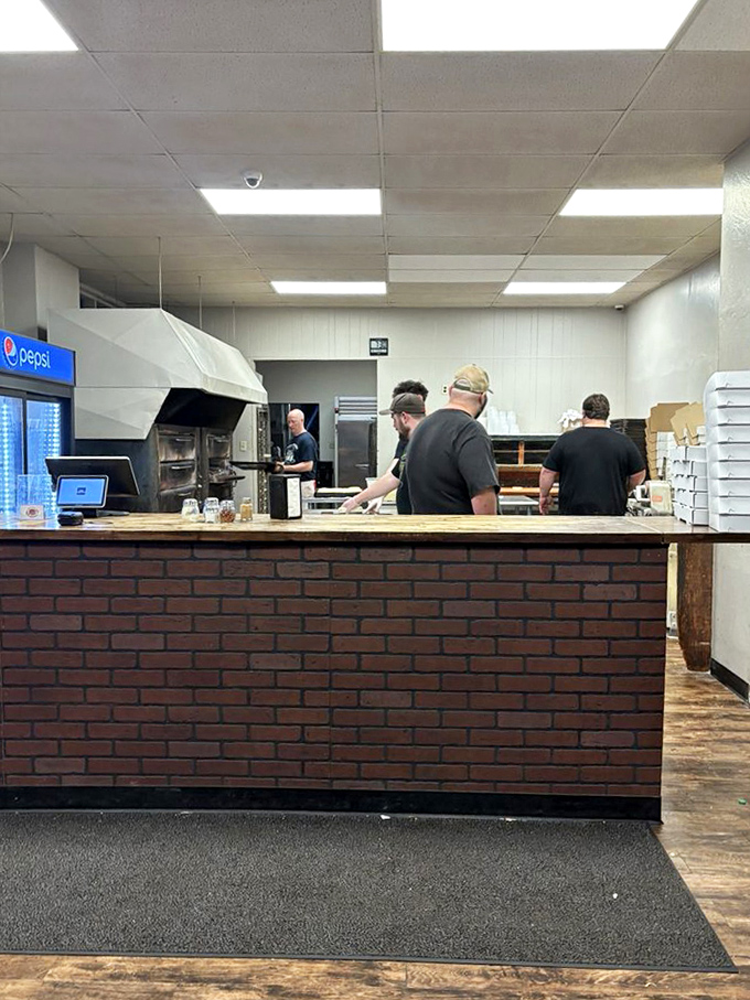 Behind the scenes, the pizza artisans work their magic, transforming simple ingredients into the stuff of local legend.