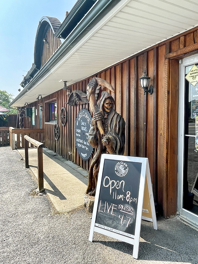 A wooden sentinel guards the entrance, while a chalkboard promises live music&mdash;because good food deserves a soundtrack.