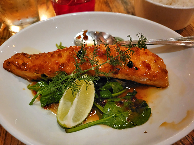 The Sweet Chili Salmon arrives like a work of art, with fresh herbs and lime creating a dish that's both Instagram-worthy and soul-satisfying.