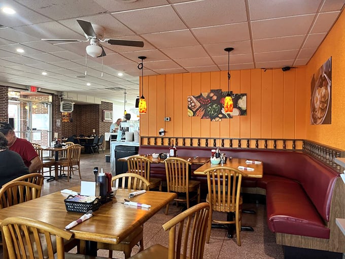 Orange walls and wooden booths create that perfect diner atmosphere where conversations flow as freely as the coffee and judgment stays at the door.