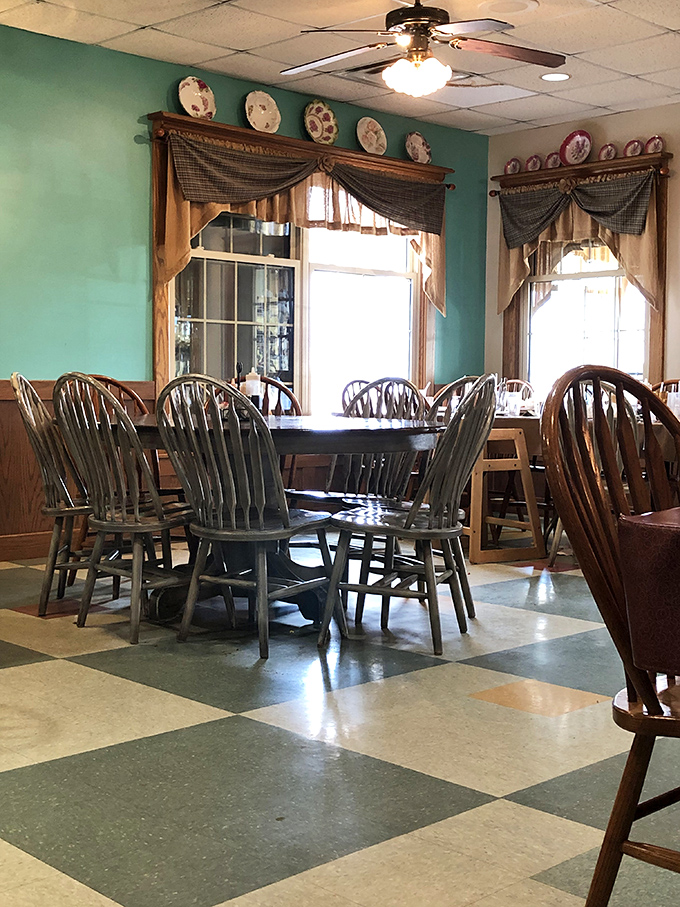 Turquoise walls, decorative plates, and Windsor chairs—dining room decor that says "Welcome home" without saying a word.