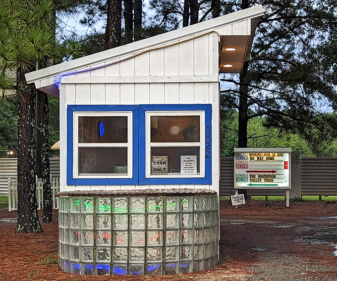 The ticket booth stands like a sentry at the entrance, its glass block foundation adding a touch of retro charm to your movie night.