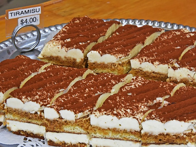 Tiramisu sliced with mathematical precision, each piece promising the perfect ratio of coffee-soaked cake to mascarpone cream.