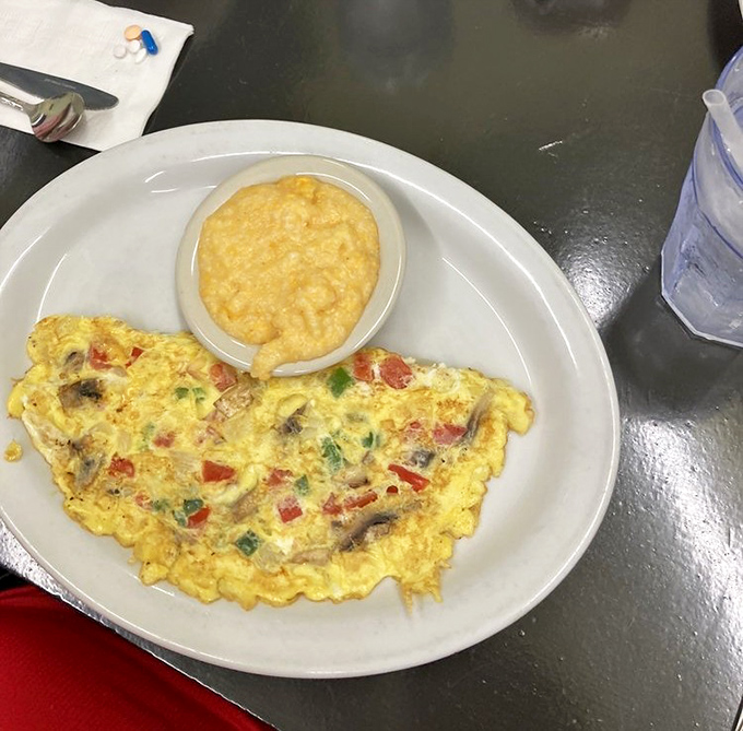 A veggie omelet that proves eating your vegetables can be a joy, especially when paired with grits that achieve that perfect creamy consistency.