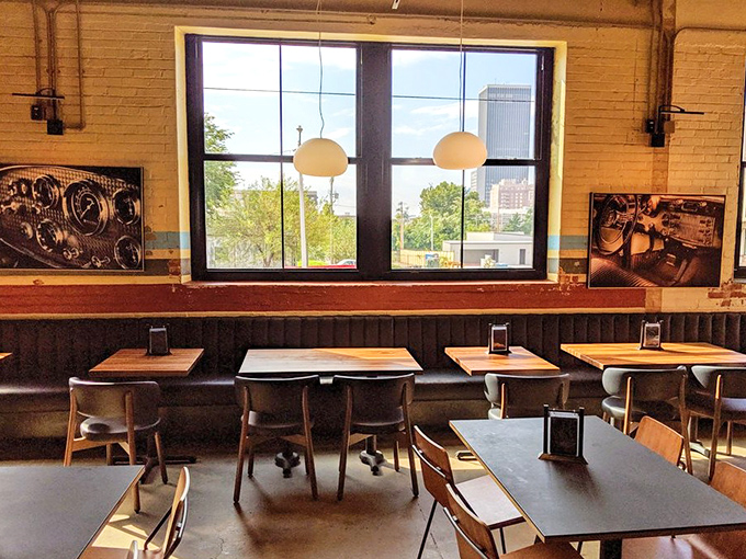 Window seats framing downtown OKC like portraits of urban renaissance, with tables positioned for optimal people-watching and skyline views.