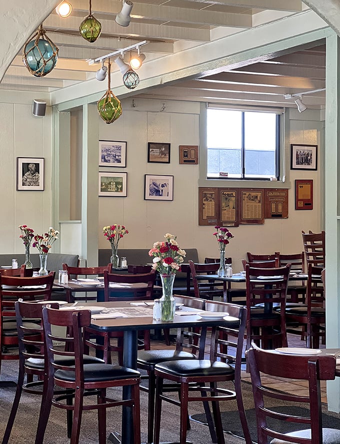 Colorful glass floats and black-and-white photos create a maritime museum vibe. Each table gets its own fresh flower centerpiece&mdash;a small but meaningful touch.