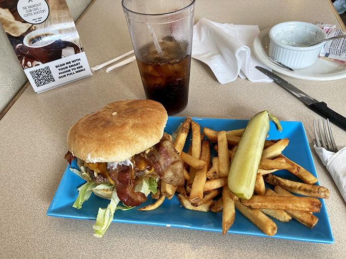 A burger that demands a two-handed commitment, served with fries so perfectly golden they deserve their own Instagram account.