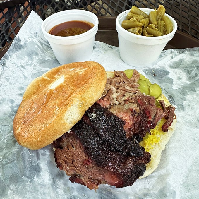 The barbecue sandwich in its final form&mdash;bark-crusted brisket with pickles for tang and a bun that knows its supporting role.