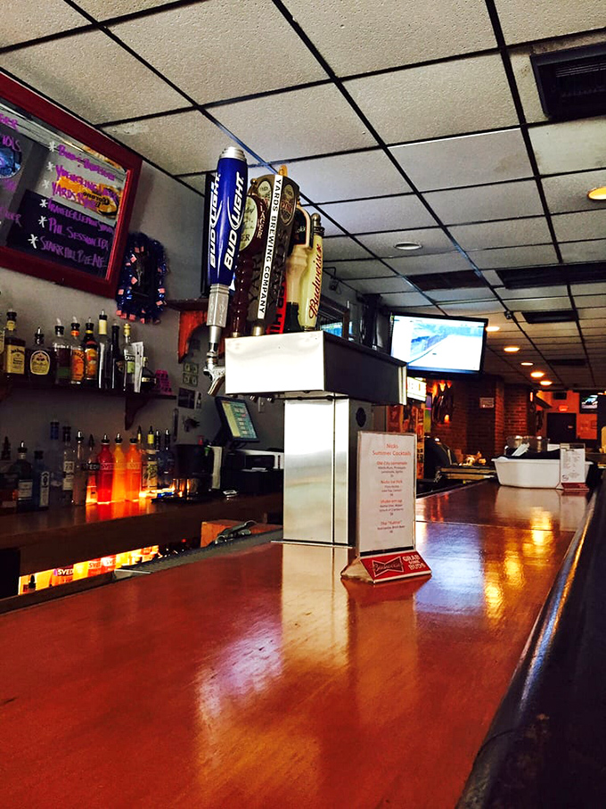 The polished wood bar stretches like a runway for drinks, each tap handle standing at attention, ready for duty.