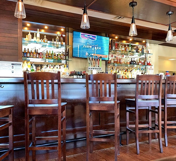 A bar setup that says "we take our drinks as seriously as our food." Those wooden chairs have probably heard some great stories over the years.