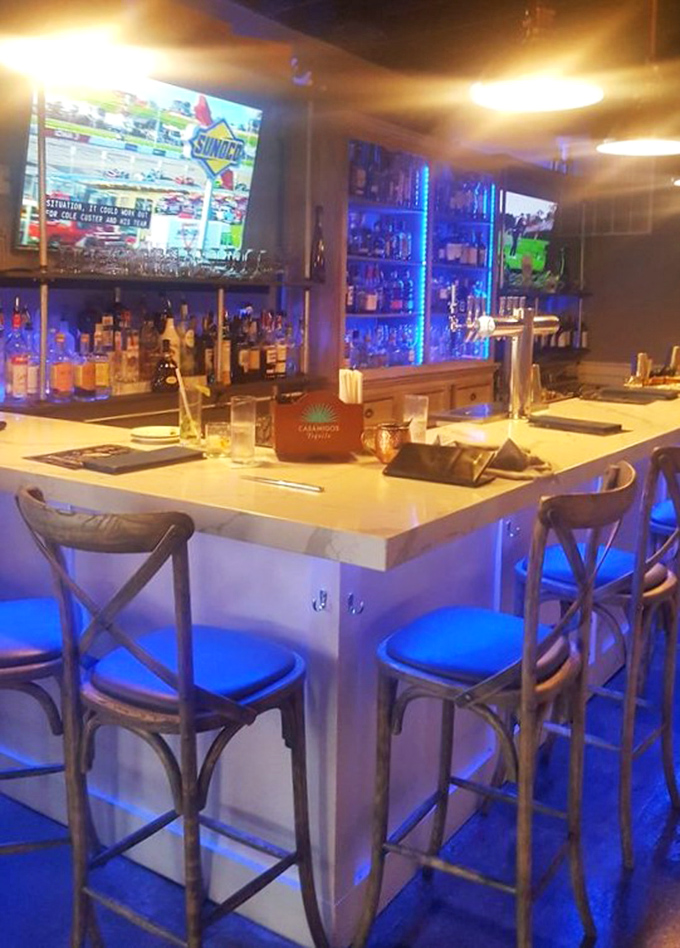 The bar glows with blue promise&mdash;where sports on TV and premium spirits create that perfect "one more before we go" atmosphere.