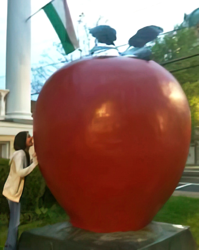 The irresistible urge to pretend-bite the giant apple proves that some photo ops are universally appealing, regardless of age.
