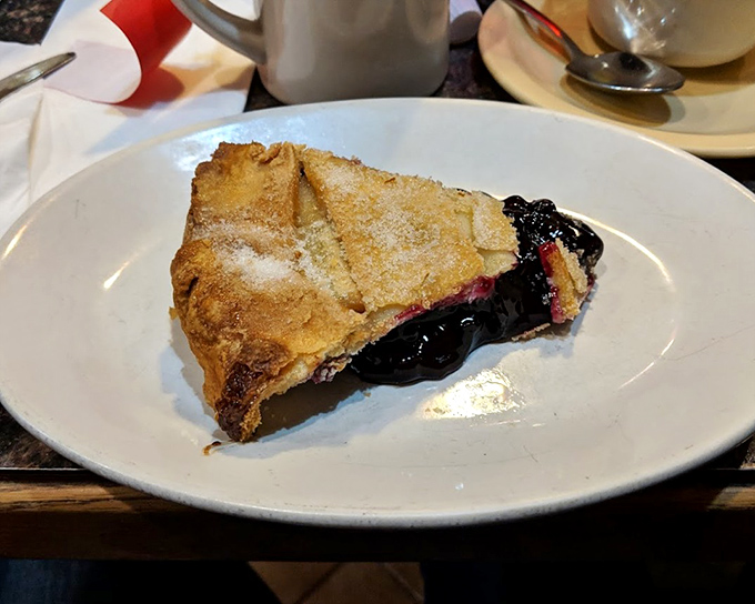 A slice of blueberry pie that makes a compelling case for dessert at breakfast. The flaky crust-to-filling ratio is mathematical perfection.