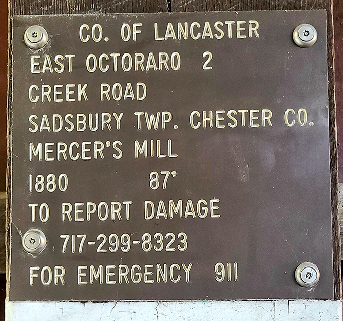 A weathered plaque reveals the bridge's 1880 construction date—87 feet of history spanning Octoraro Creek for nearly a century and a half.