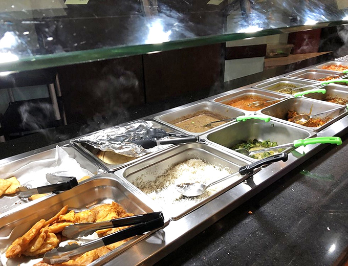 The buffet line—where indecision becomes your friend. Each metal tray contains a different chapter of the same delicious story.