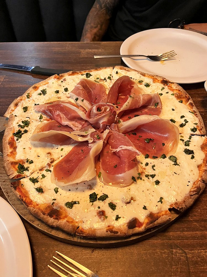 Prosciutto arranged like a delicate rose atop a white pizza&mdash;proof that Italians understood food as art long before Instagram.