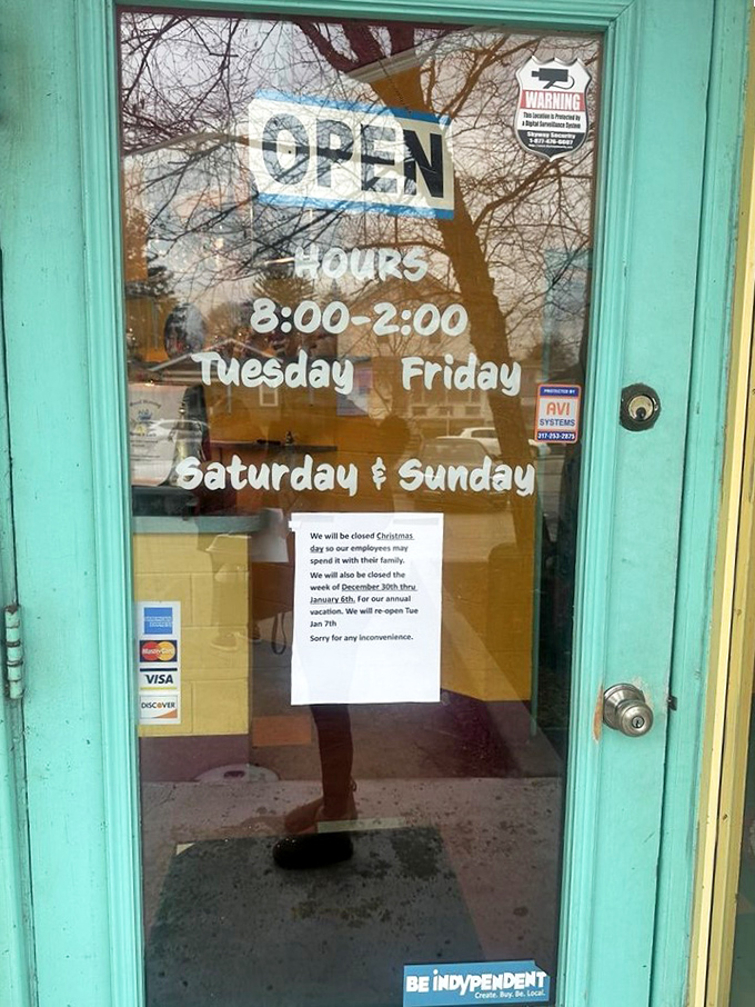 The turquoise door frame announces operating hours like an invitation to happiness between 8 and 2.