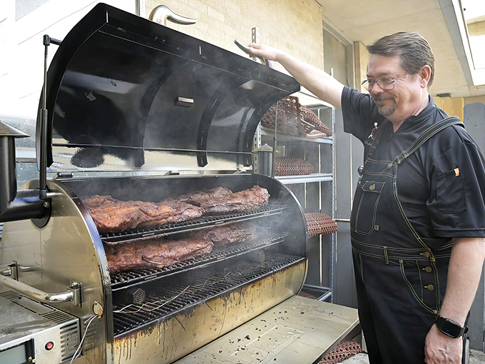 The pitmaster reveals his craft&mdash;racks of ribs basking in that perfect combination of smoke, time, and expertise.