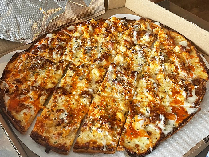 The Chicken Limo pizza, cut into perfect squares, proves that buffalo sauce and ranch dressing belong on more than just wings.