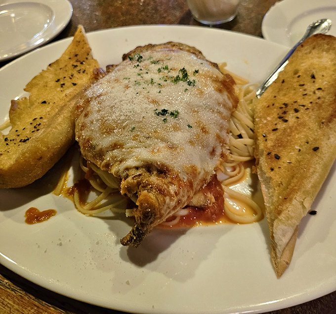 Chicken Parmigiana that doesn't mess around&mdash;golden-crusted, cheese-blanketed, and flanked by garlic bread sentinels ready to soak up every last bit of sauce.