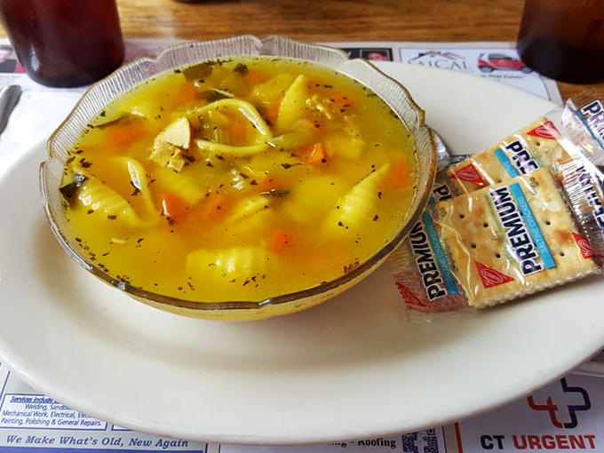 A bowl of chicken soup that could cure everything from the common cold to existential dread, served with crackers for proper dunking protocol.