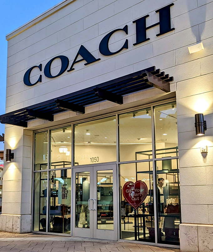 Coach's elegant storefront promises leather goods that whisper "I've made it" without the full-price shouting match with your bank account.