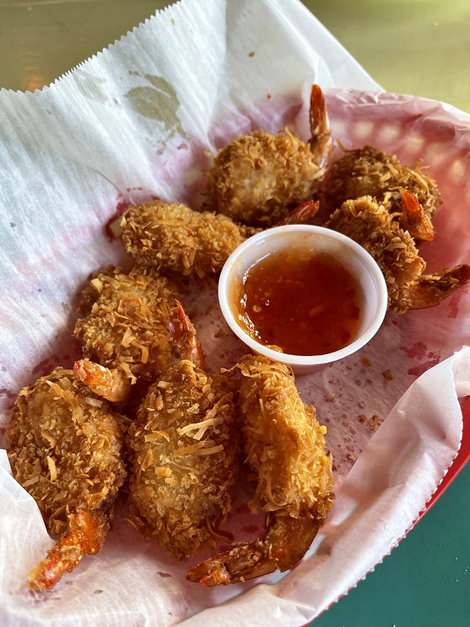Coconut shrimp that look like they're wearing tiny tropical tuxedos, all dressed up and ready to dive into that sweet dipping sauce.