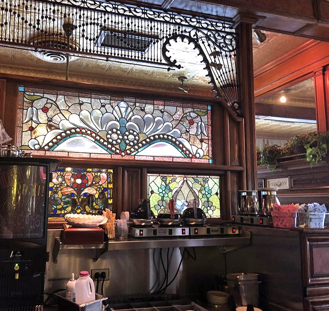 Ornate stained glass backdrops the coffee station &ndash; even the practical elements here are framed by unexpected beauty.
