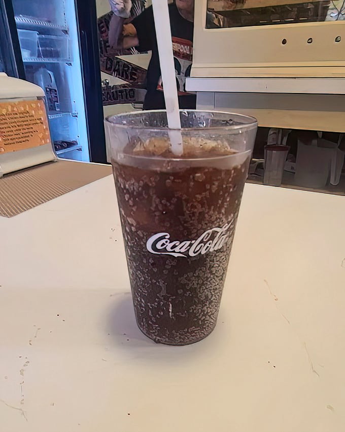 An ice-cold Coca-Cola in a classic glass, the perfect companion for hot dogs that refuse to apologize for their greatness.