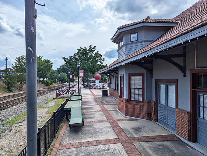 The Cornelia Historic Train Museum preserves the town's railroad heritage, with the Big Red Apple visible in the distance like a watchful guardian.