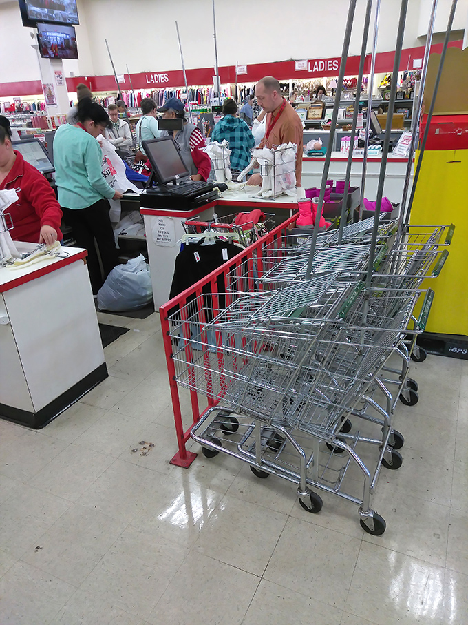 The checkout line: where triumphant hunters gather to show off their spoils. The red shopping carts stand ready for the next wave of bargain seekers.
