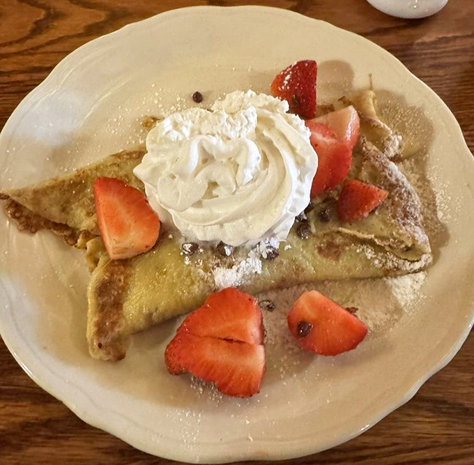 A crepe that's dressed for success &ndash; delicate, buttery, and adorned with fresh strawberries and whipped cream like jewelry on breakfast royalty.