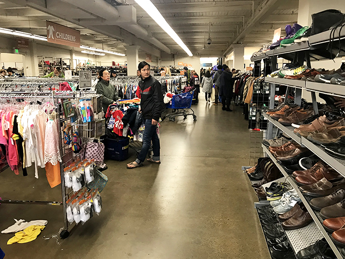 Treasure hunters navigate the clothing aisles with practiced eyes, scanning for that designer label hiding among the everyday brands.