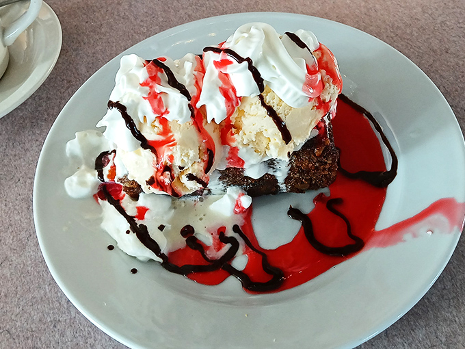 A slice of cake that doesn't just end a meal—it crowns it, with chocolate, whipped cream, and berries playing their perfect supporting roles.