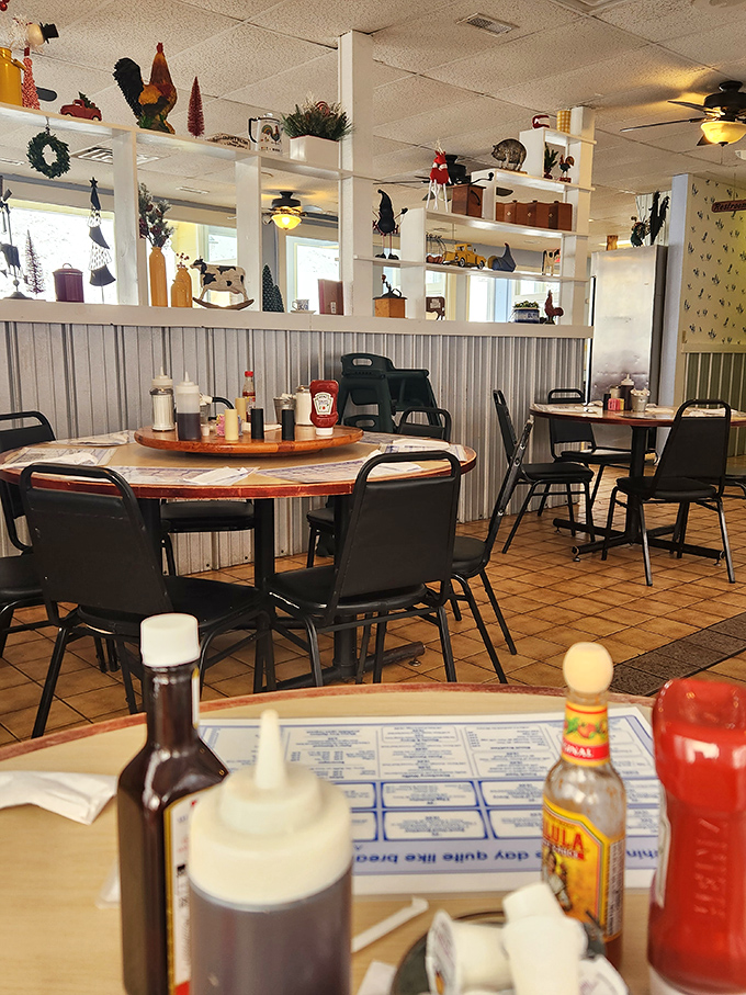 Charming country decor creates the perfect backdrop for morning conversations. The rooster-themed shelf displays remind you that breakfast is serious business in these parts.