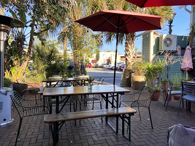 Outdoor dining surrounded by palms and potted plants&mdash;nature's way of saying, "Take your time, the office emails can wait."