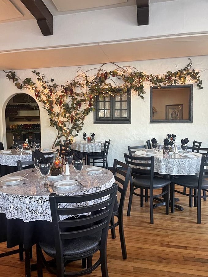 Dining tables adorned with lace cloths beneath illuminated vines—it's like eating inside a romantic Italian film without the subtitles.