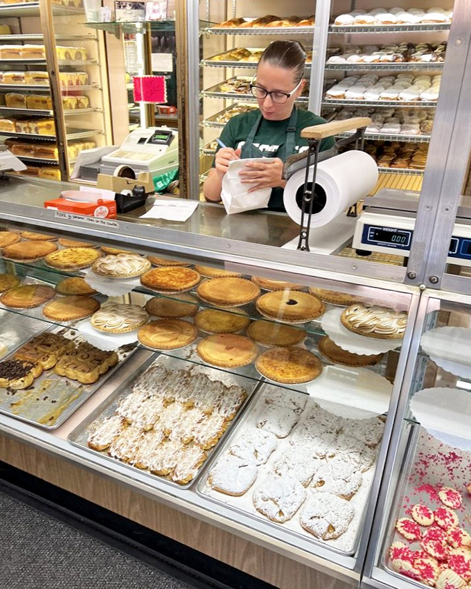 Behind every great bakery is a dedicated team&mdash;this display case worker is the gatekeeper to a world of sweet possibilities.