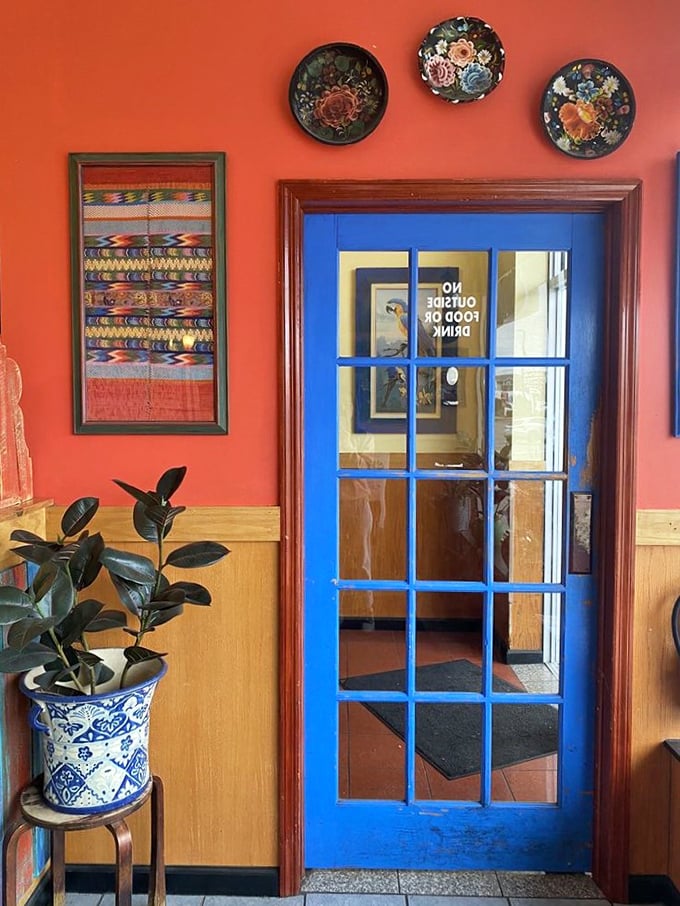 That blue door framed by warm terracotta walls isn't just an entrance – it's a portal to flavor town. The decorative plates above hint at the cultural fusion waiting inside.