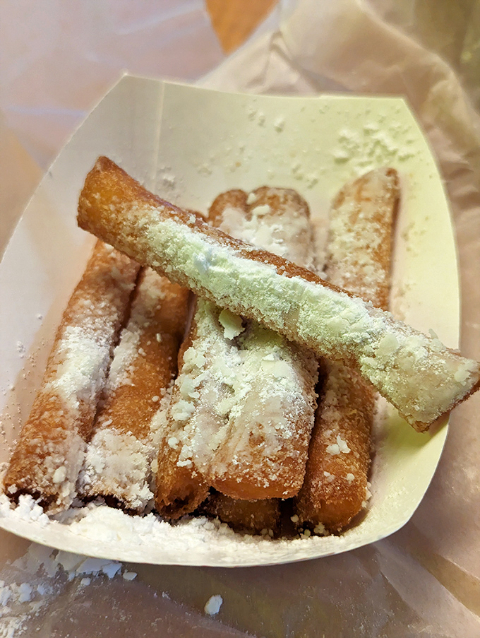 Funnel cake fries dusted with powdered sugar—where carnival joy meets everyday indulgence in a handheld package of happiness.