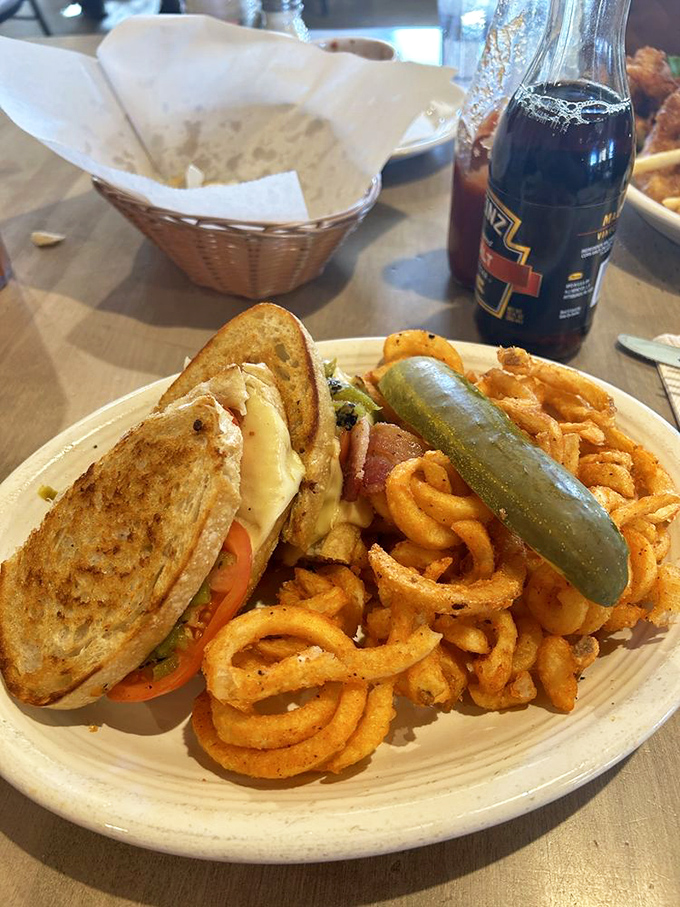 The humble grilled cheese, elevated to art form with perfect golden bread, melty cheese, and those addictive curly fries that disappear mysteriously fast.