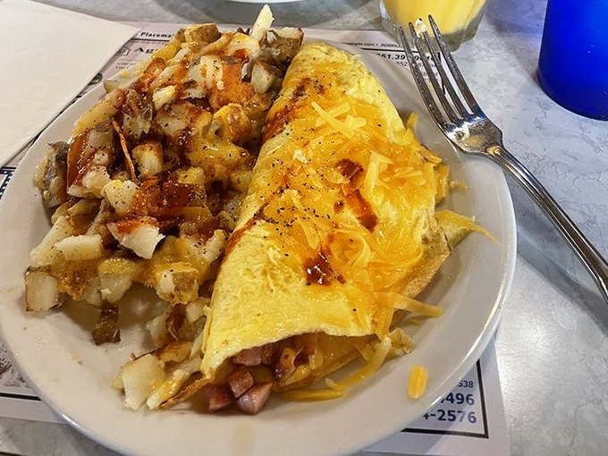 An omelet that's seen things, done things, and has stories to tell. The potatoes on the side are its loyal sidekicks.
