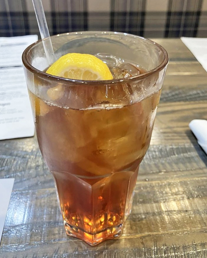 A tall glass of amber iced tea with lemon&mdash;simple, refreshing, and the perfect companion to whatever deliciousness you've ordered.