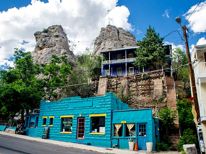 This blue building nestled against dramatic rock formations proves that in Bisbee, even the backdrop for your morning coffee deserves a standing ovation. 