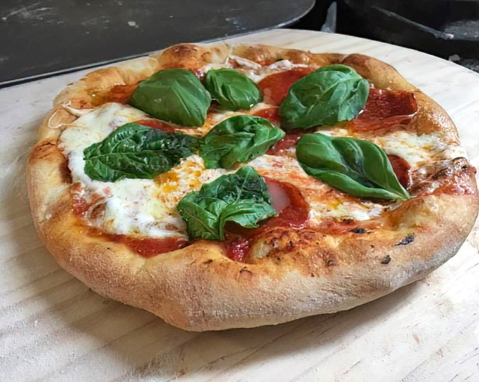 A pizza that reminds you simplicity is the ultimate sophistication. Fresh basil leaves aren't just garnish – they're little green flags of flavor victory.