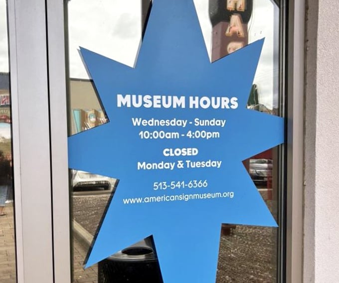 The museum hours sign shaped like a starburst&mdash;because when you're in the sign business, even your schedule deserves flair.