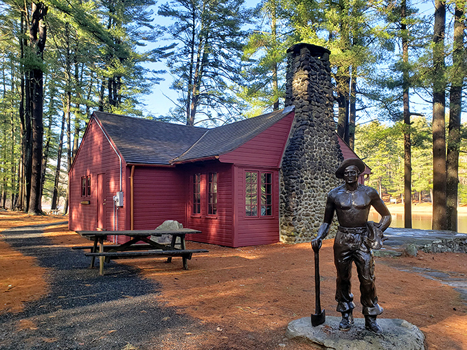 The rustic red cabin and CCC worker statue tell stories of Depression-era conservation efforts. History you can touch.